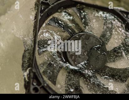 Closeup of computer case fan frozen in block of ice. Concept keep your ...