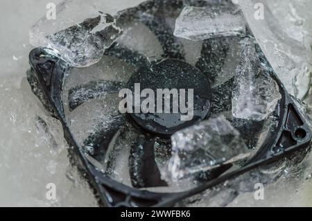 Closeup of computer case fan frozen in block of ice. Concept keep your ...