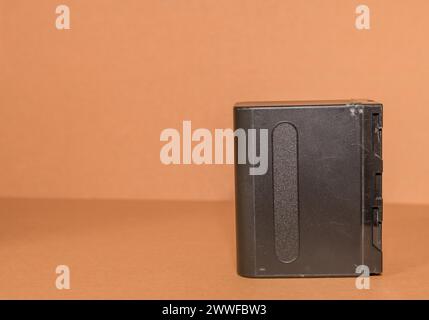 Closeup side view of used Lithium-ion battery on brown background ...
