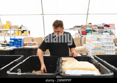 Volunteer man preparing donation boxes for people Stock Photo - Alamy