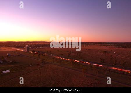 Aerial of sunset over trucks delivering wheat grain to the silo's ...