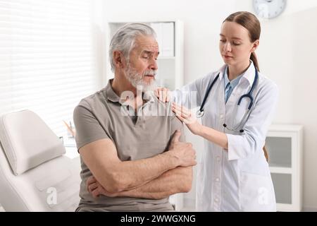 Arthritis symptoms. Doctor examining patient with shoulder pain in ...