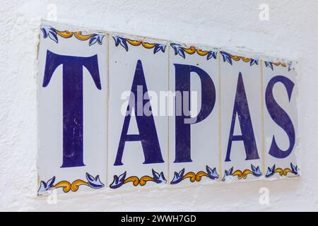 Tiled sign with the word Tapas in blue letters Stock Photo - Alamy