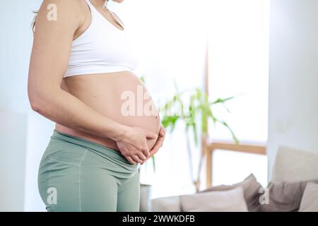 Description: Lateral view of midsection of unrecognizable woman gently ...