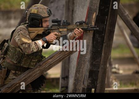 An Albanian special operations forces soldier takes cover behind tires ...