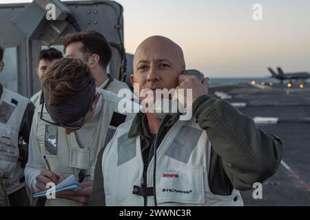 A landing signal officer (LSO) and his assistant monitor the approach ...