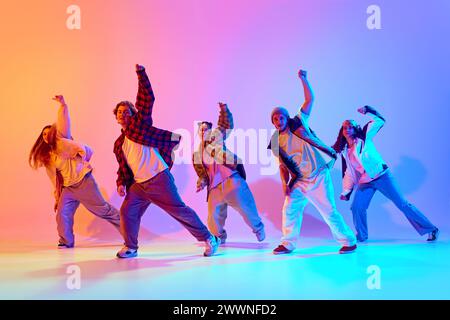 Synchronized movements. Group of young people dancing contemp against ...