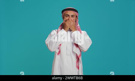 Muslim guy covers eyes, ears and mouth on camera, showing three wise ...