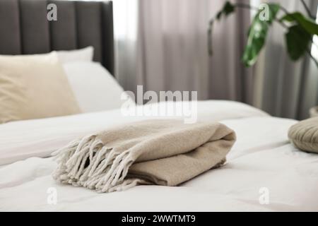 Soft beige plaid on bed in stylish bedroom. Interior design Stock Photo ...