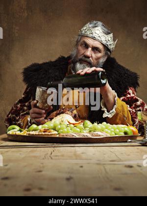 Portrait, king and feast in table with wine as royalty on dining hall ...
