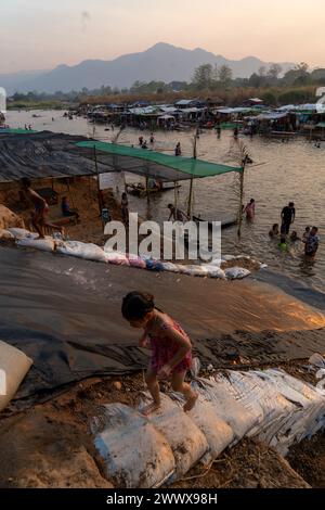 Thai and Burmese families swimming and playing in the Thailand-Myanmar ...