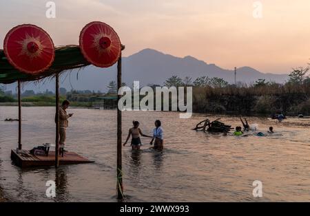 Thai and Burmese families swimming and playing in the Thailand-Myanmar ...