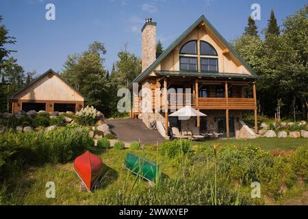 Garage and handcrafted two story spruce log cabin home with fieldstone ...