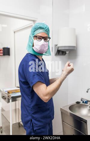 veterinary man surgeon in epi clothes preparing to operate washing ...
