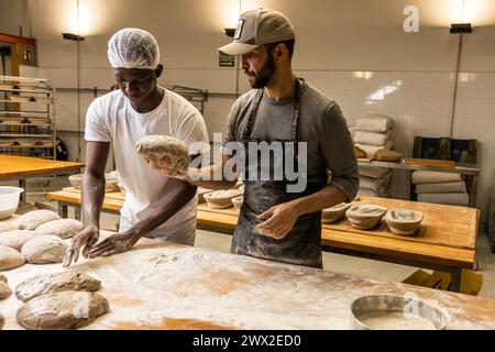 master baker teaching the technique to his apprentice in the bread ...