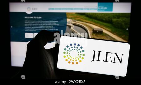 Person holding smartphone with logo of environmental label Cradle to ...