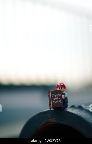 Lego minifigure Peter Parker sitting and reading a book with blurred ...