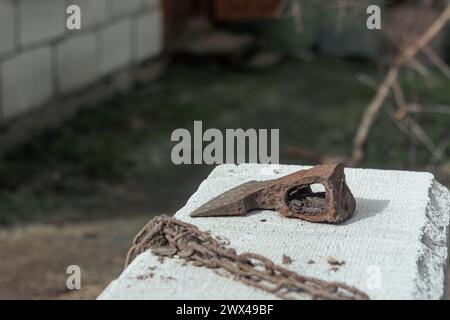 Abstract of Lumberman tools with broken rusted axe, head, chain on a ...