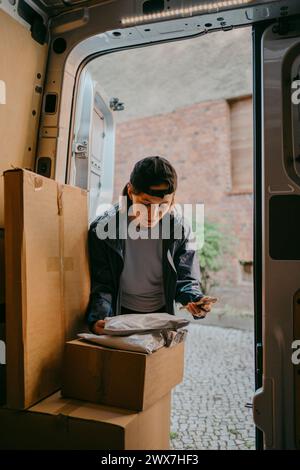 Courier with parcels near delivery van outdoors Stock Photo - Alamy