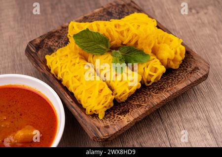 Close up of Roti Jala or Net Bread and curry sauce on white background ...