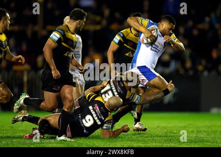 Sam Lisone of Leeds Rhinos is tackled by George Griffin of Castleford ...