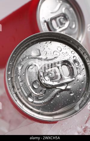 Tin cans and ice cubes on white background Stock Photo - Alamy