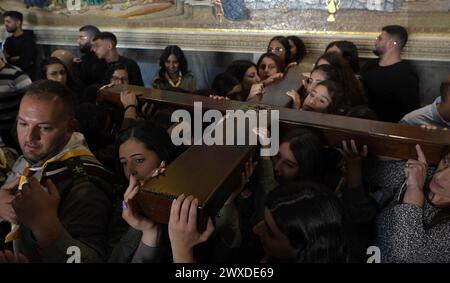Christian Arab scouts carry a large wooden cross inside the Church of ...