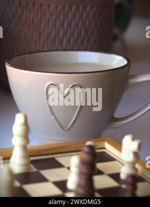 Chess game - chess board with the chess pieces and a coffee mug ...