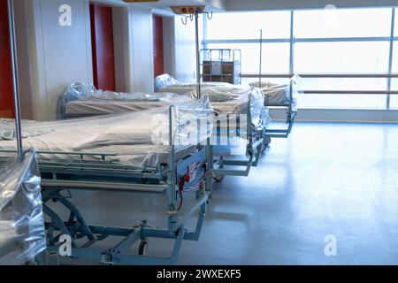 Clean hospital beds covered with film, ready for new patients. Hospital ...