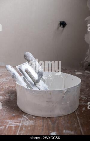 Applying decorative putty. White abstract texture of surface covered ...