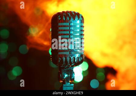 Retro microphone and flame against blurred lights, closeup Stock Photo ...