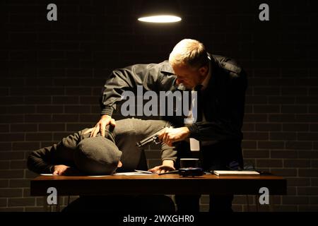 Mature FBI agent threatening suspect with gun in interrogation room ...