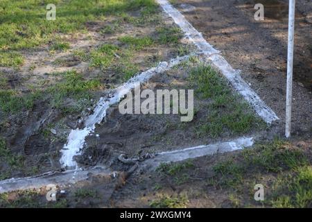 Corner quadrant of football pitch showing pitch markings and mud muddy ...