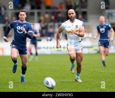 Tom Roebuck of Sale Sharks and Olly Woodburn of Exeter Chiefs chase a ...