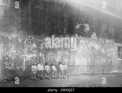 Dead line at the arsenal, Santiago, prisoners lined up against a stone ...
