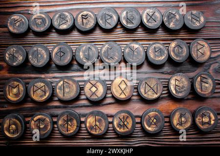 Anglo-saxon wooden handmade runes on the vintage table On each rune ...