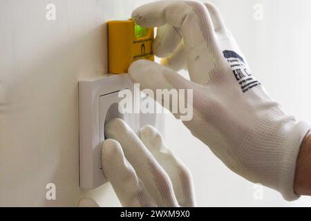 Leveling during the installation of a new electrical outlet on the wall ...