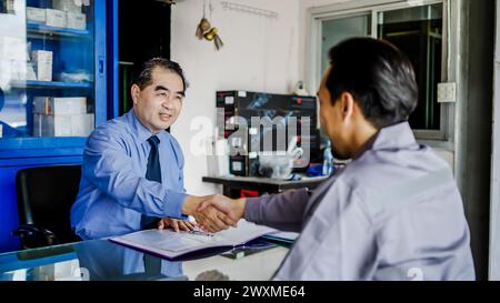 A mechanic discussing car repairment with another person in a garage ...