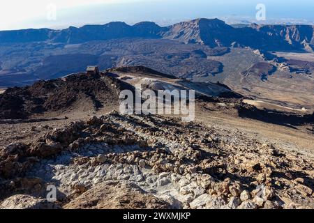 Rugged volcanic landscape with rocky ridges under a cloudy sky at dusk ...