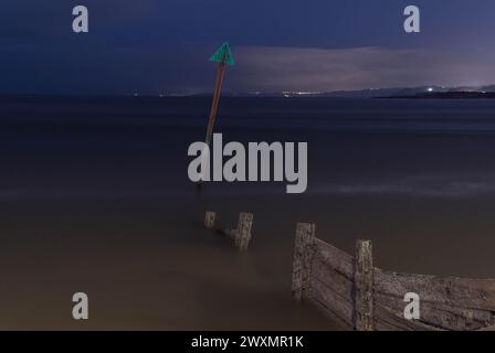 Triangular sea marker at the end of a decaying wooden groyne, Exmouth ...