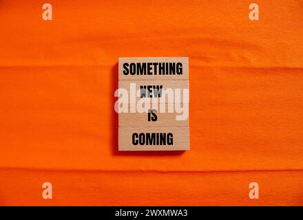 Something new is coming words written on pink torn paper piece with ...