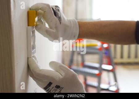 Leveling during the installation of a new electrical outlet on the wall ...