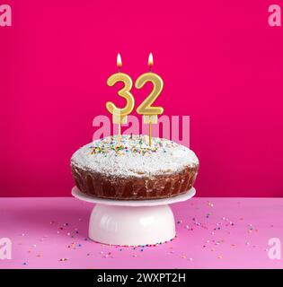 Lighted birthday candle number 32 - Yellow background with blue ...