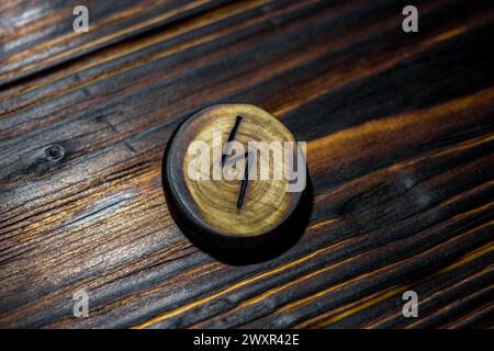 Rune Sowilo (Sigel, Sol) carved from wood on a wooden background ...