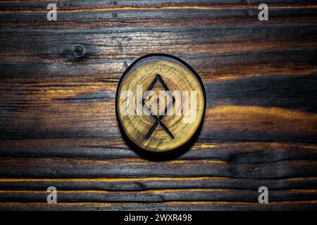 Rune Odal (Othala) carved from wood on a wooden background - Elder ...