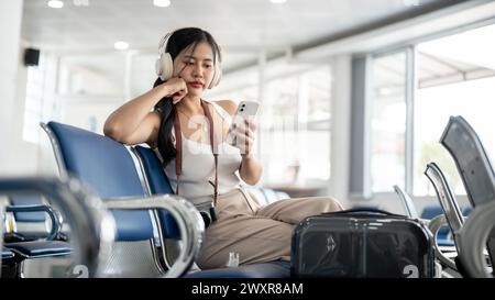 A beautiful Asian female passenger is feeling tired and bored while waiting for her boarding ...