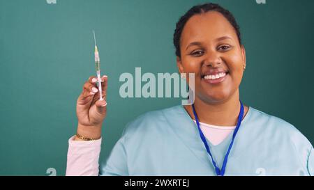 Black female doctor draws up injection, vaccine vial, needle, IVF ...