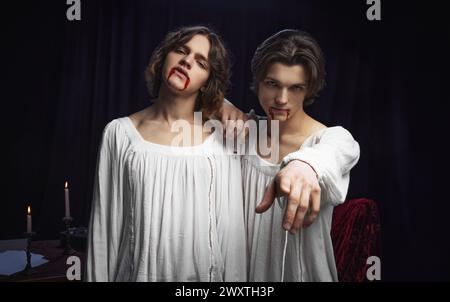 Two handsome man looks as vampires in old-fashion clothes looking at ...