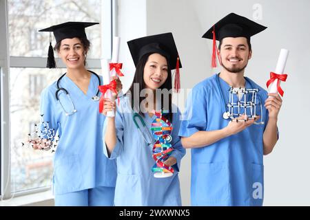 Medical graduate students with diplomas, DNA and molecular models in ...