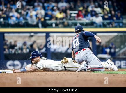Milwaukee Brewers' Jake Bauers attempts to score as he slides into home ...